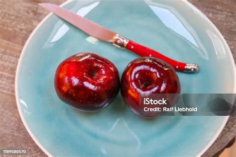 칼로 파란색 중국 접시에 고립 된 두 개의 빨간 점선 반짝 이별 디저트 사과의 닫습니다 건강한 식생활에 대한 스톡 사진 및 기타 이미지 건강한 식생활 과일 독일