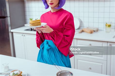 보라색 머리와 부엌에 팬케이크의 접시를 들고 화려한 옷 주부의 부분 보기 보라색머리에 대한 스톡 사진 및 기타 이미지 보라색머리 가사 집안일 가정 생활 Istock