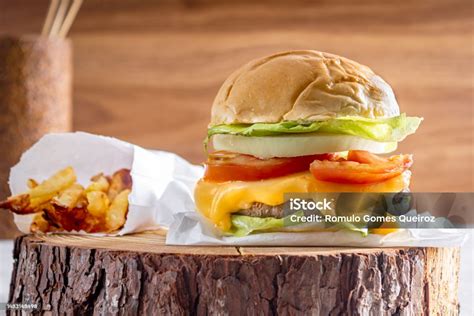 나무 통나무와 나무 배경 위에 체다 치즈를 곁들인 맛있는 햄버거 옆에 감자 튀김 0명에 대한 스톡 사진 및 기타 이미지 0명 고기 굽기 Istock