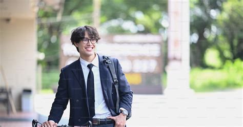 웃고 있는 젊은 사업가가 거리에서 자전거를 타고 걷고 있다 에코 교통 개념입니다 사진 Unsplash의 사업 이미지