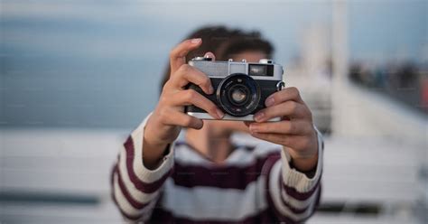 해질녘 바다 부두에서 카메라로 사진을 찍는 소녀의 클로즈업 휴일 개념 사진 Unsplash의 슬로바키아 이미지