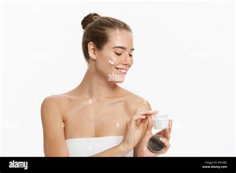 Beautiful Young Woman Applying Cosmetic Cream Treatment On Her Face