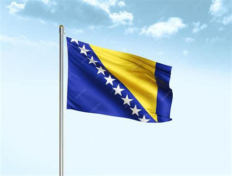 Premium Photo Bosnia And Herzegovina National Flag Waving In Blue Sky