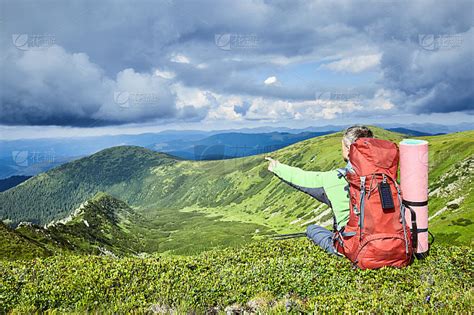 在夏天背着背包在山上徒步旅行。