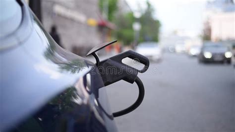 A Cable At A City Charging Station Charges An Electric Car In Close Up
