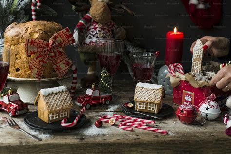 진저브레드 하우스로 테이블을 장식하는 사람 사진 Unsplash의 크리스마스 이미지