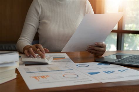 사업가 또는 회계사가 사무실에서 비즈니스 재무 데이터 회계 문서 및 랩톱 컴퓨터를 계산하기 위해 계산기로 작업하는 클로즈업