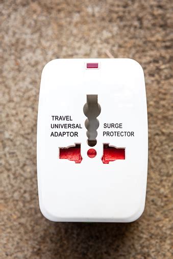 여행에 사용되는 범용 전기 소켓 플러그 어댑터를 닫습니다 전 세계 여러 전기 콘센트에 연결하는 데 사용됩니다 어두운 배경에 격리 된 전기 어댑터 개인 장식품에 대한 스톡