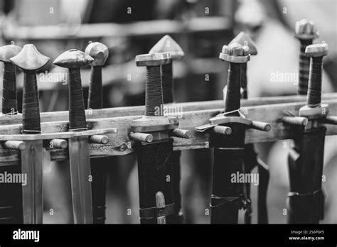 A Row Of Swords Are Hanging On A Rack The Swords Are All Different