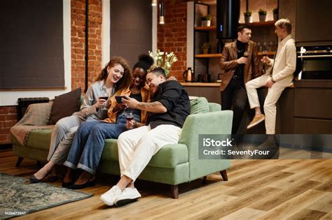 소파에서 스마트 폰으로 사진을 들여다 보는 세 명의 행복한 이문화 소녀 20 24세에 대한 스톡 사진 및 기타 이미지 20 24세 35 39세 5명 Istock