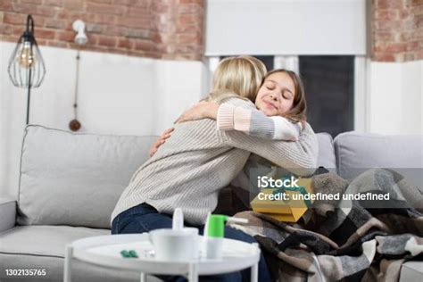 차가운 또는 독감과 행복한 귀여운 아픈 십대 소녀 집에서 그녀의 생일을 축하 그녀의 어머니는 포옹하고 그녀에게 선물 상자를