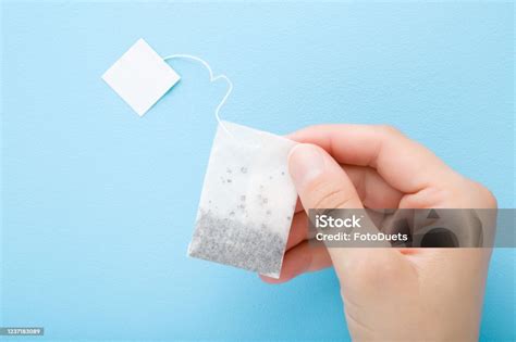 밝은 파란색 테이블 배경에 홍차 가방을 들고 젊은 여성 파스텔 색상입니다 근접 촬영 시점 샷 하향하 보기 제품용기에 대한 스톡 사진 및 기타 이미지 Istock