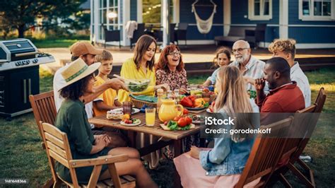 부모 자녀 친척 및 친구들이 뒷마당에서 야외 채식 저녁 식사를합니다 노인과 젊은이들은 이야기하고 채팅하고 재미있게 놀고 먹고 마신다 뒤뜰에서 정원 파티 축하 가족에 대한
