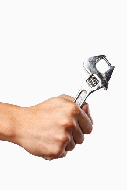 Premium Photo Cropped Hand Holding Spanner Over White Background