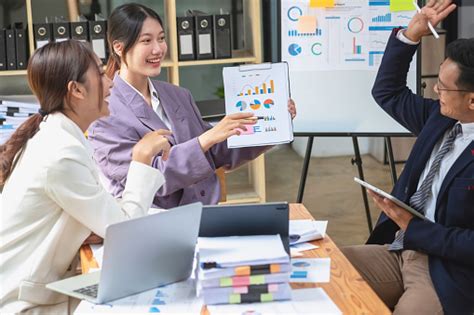 아시아 비즈니스 팀은 마케팅 직원으로 구성됩니다 회계사 및 재무 책임자 태블릿을 사용하여 회사 이익을 분석하도록 서로 도와주세요 계산기 노트북 컴퓨터 그래프 용지 및 회사