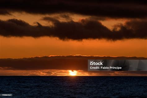 테네리페 카나리아 섬 스페인에서 바다 위에 놀라운 일몰과 자연 해양 풍경 열대 섬에서 여름 이국적인 휴가 엽서입니다 구름 뒤에 물 위에 멋진 오렌지 일출 0명에 대한 스톡