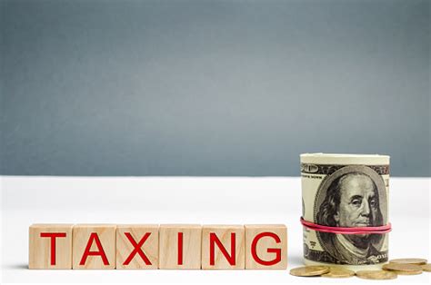 단어와 나무 블록 Taxing와 달러 과세 의무의 부과 개인 이나 단체에 정부에 의해 부과 럭셔리에 소득에 세금입니다 국가에 세금의 지불 가계에 대한 스톡 사진 및 기타