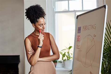 마케팅 프리젠 테이션 및 코칭 학습 및 개발을 위해 화이트 보드에 글을 쓰는 비즈니스 여성과의 교육 여성 직원이 전략을 논의하는