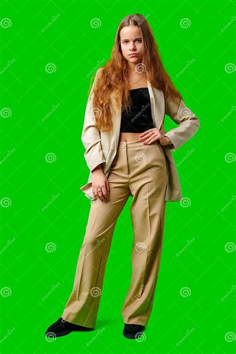 Young Woman Posing In Beige Suit Against Green Background Stock Image