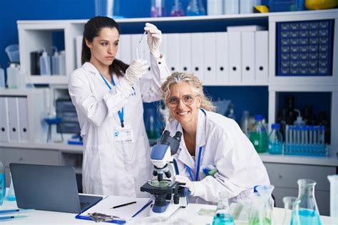 Premium Photo Two Women Scientists Using Microscope Measuring Liquid At Laboratory