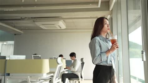 한국 비즈니스 회사 사무실 창가에 서서 커피를 마시고 있는 젊은 비즈니스우먼 모습 동영상 Jkr221660 게티이미지뱅크