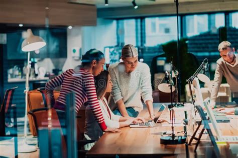 Three Young Women In A Modern Office Solve A Problem Together While