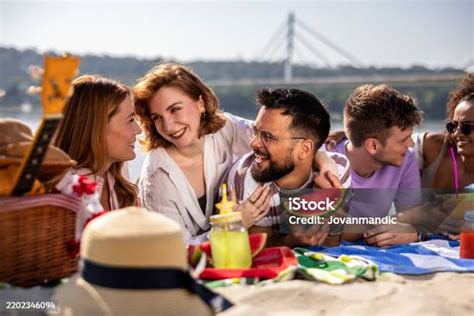 해변에서 피크닉을 즐기는 5명의 다인종 친구들 그들은 수박을 먹고 다채로운 칵테일을 마시고 그들 곁에는 기타가 있습니다 20 24세에 대한 스톡 사진 및 기타 이미지