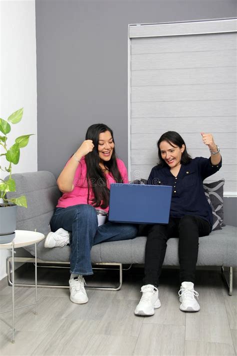 Two Women Use Laptop To Shop Find Discounts And Promotions Excited And Enthusiastic Stock Photo