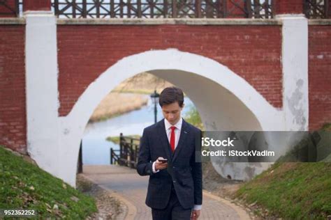 젊은 사람 십 대 클래식 정장 그는 그의 손에 스마트폰을 보유 하 고 이동 중에 보는 긍정적인 감정 표현에 대한 스톡 사진 및 기타 이미지 Istock