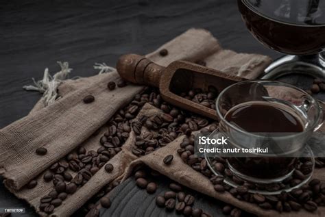 나무와 어두운 돌 배경에 오래된 나무 국자와 커피 콩으로 가득 찬 커피와 커피 콩 한 잔 텍스트에 대한 복사 공간이 있는 상단의 경사 보기입니다 갈색에 대한 스톡 사진 및