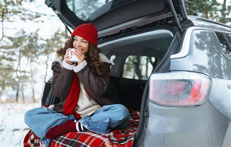젊은 여자는 보온병을 들고 겨울 숲의 자동차 트렁크에 앉아 차를 마신다 차에 대한 스톡 사진 및 기타 이미지 차 가을 머그 Istock