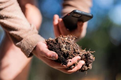 Premium Photo Soil Scientist Agronomist Farmer Looking At Soil Samples And Grass In A Field In
