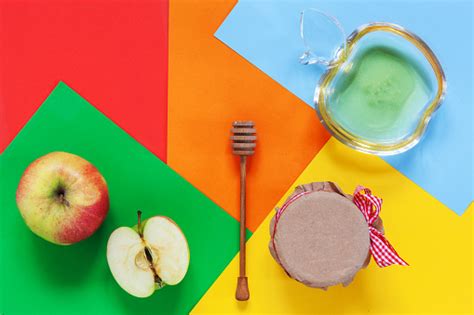 사과와 꿀 유대인의 새해로 로쉬 하샤나에 대한 개념 밝은 여러 가지 색상의 종이 배경에 클로즈업 한 상단 보기 가을에 대한 스톡