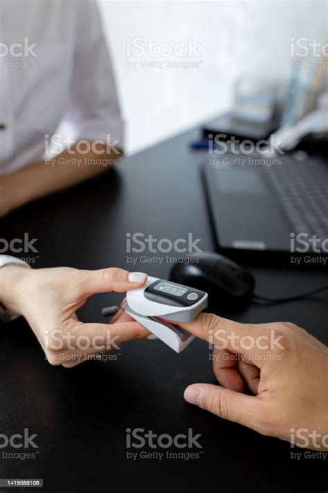 여성 의사는 클리닉에서 환자를위한 맥박 산소 측정기 혈액 산소 포화도에 의해 측정합니다 산소 포화도 측정기에 대한 스톡 사진 및