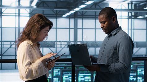 Server Farm Workers Using Devices To Perform Vulnerability Scans Stock