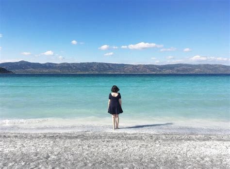 Premium Photo Rear View Of Woman Standing At Lakeshore Against Blue Sky