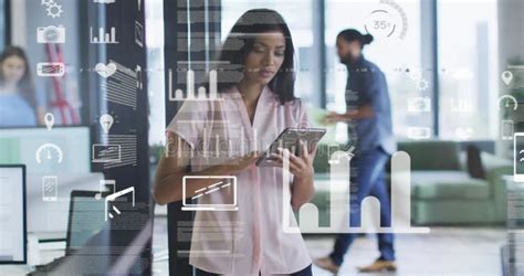 Animation Of Mobile Icons And Coding Over Biracial Businesswoman Using Tablet In Office Stock
