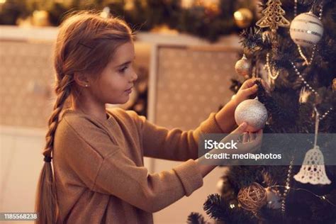 크리스마스 트리에 의해 서 집을 장식하는 동안 나무에 Bauble매달려 머리띠와 콘텐츠 귀여운 소녀 아이에 대한 스톡 사진 및 기타 이미지 Istock