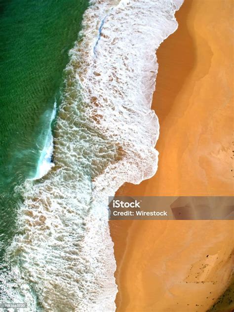 Aerial View Of A Stunning Sandy Beach With Crystal Clear Blue Waves