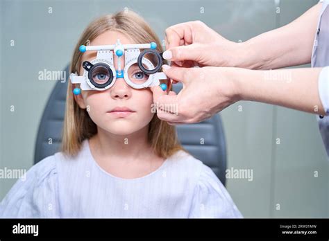 Experienced Optometrist Conducting Subjective Refraction Test On Little