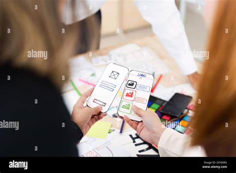 Creative Ux Ui Design Team Collaborating On Mobile App Interface With Wireframes And Prototypes