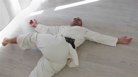 Men Lying On The Ground Do Warm Up Leg Exercises For Karate Session
