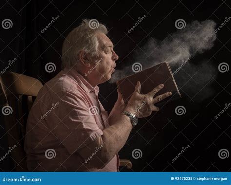 Mature Man Blowing Dust Off An Old Book Stock Image Image Of
