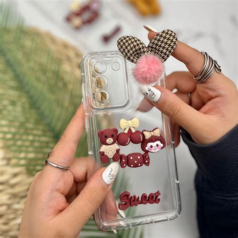 قاب گوشی سامسونگ عروسکی زرشکی برجسته سه بعدی پام پام دار رنگی ایربگ دار محافظ لنزدار Galaxy A04s