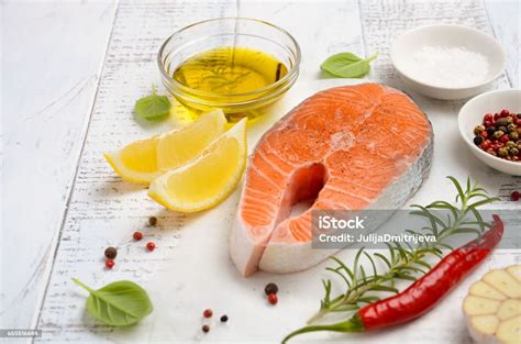 레몬 올리브 오일 소박한 나무 배경에 향신료와 신선한 생 연어 스테이크 건강 한 저녁 식사를 만들기 위한 재료입니다 건강 한 다이어트 개념입니다 연어 해산물에 대한 스톡