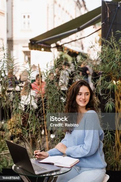 원격 교육 매력적인 소녀는 카페에서 야외에서 노트북으로 타이핑하고 채팅합니다 노트북을 가진 집중 영어 교사는 외부 화상 통신을 통해 온라인 수업을합니다 18 19세에 대한