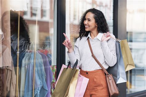 행복 쇼핑몰과 가방을 가진 여자와 패션 판매와 창문에 반사에 미소 옷 할인 판매 및 소매 요법 부티크 밖에서 쇼핑백을 들고 웃고 있는 두바이의 여성 쇼핑에 대한 스톡 사진