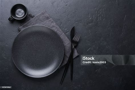 검은 숟가락 포크 칼 깨끗한 빈 검은 접시 블랙 백에 세련된 블랙과 골드 칼의 세트 유행과 고급 식사 맨 위 보기입니다 텍스트의 공간을 복사합니다 메뉴판에 대한 스톡 사진