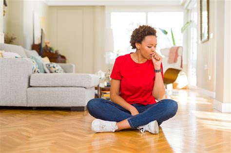 젊은 아름 다운 아프리카계 미국인 여자 집에서 바닥에 앉아 기분이 나쁘다와 기침 또는 기관지염에 대 한 증상으로 헬스케어 개념 감기와 독감에 대한 스톡 사진 및 기타 이미지