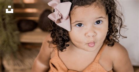 흰색과 검은색 꽃 머리띠가 있는 주황색 민소매 드레스를 입은 소녀 사진 Unsplash의 무료 소녀 이미지